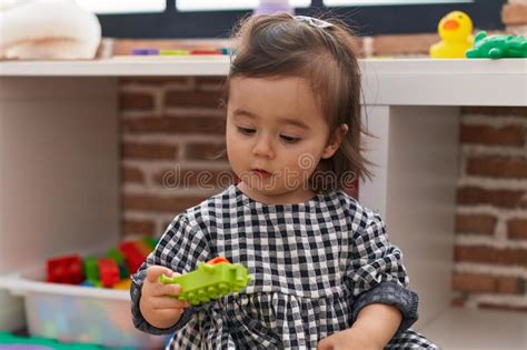 Adorable Chinese Girl Playing With Construction Blocks Sitting On Floor