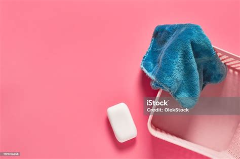 항균 비누 근처 파란색 부드러운 수건으로 세탁을위한 빈 플라스틱 사각형 바구니는 세탁에 분홍색 조리대에 놓여있습니다 텍스트의