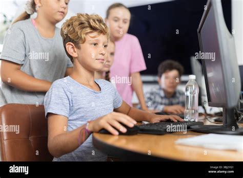 Classmates Solve Computer Problem Together In School Computer Class