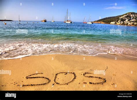 Sos Save Our Souls Rescue Word In Sand Written On Deserted Beach Island Shipwrecked Lost Alone