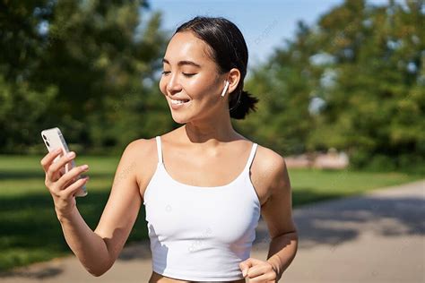 Fit Asian Girl Monitoring Running Progress On Mobile App Photo