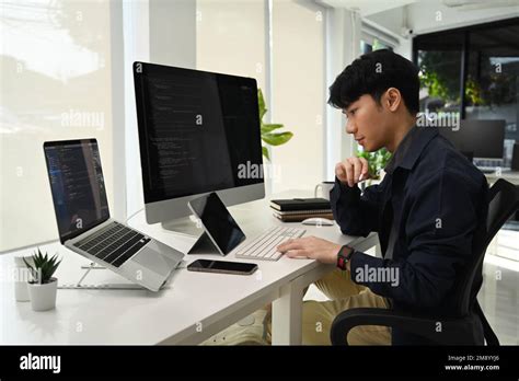 Asian Male Programmer Cooperating And Working On Web Site Project In