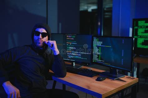 Hacker Sitting At Desk In Dark Atmosphere A Computer Programmer Or