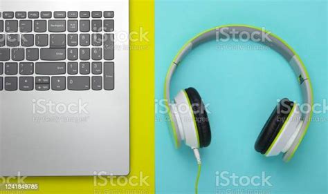 파란색 녹색 배경에 헤드폰이있는 노트북 Dj 게임 엔터테인먼트 또는 레저 개념 맨 위 보기입니다 플랫 레이 노트북에 대한 스톡
