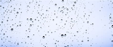 흰색 유리에 빗방울이 있는 최소한의 조명 배경 비오는 물방울이 있는 가벼운 젖은 창문이 푸른 빛으로 근접 촬영됩니다 빗방울이 있는 창 유리의 흐릿한 미니멀리스트 흑백 배경이