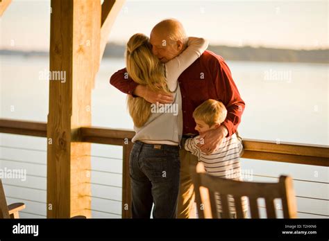 Grandfather Mother And Son Embracing On Balcony Stock Photo Alamy