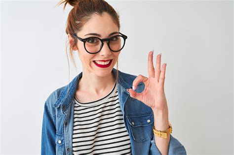 빨간 머리 여자 입고 데님 셔츠와 안경 위에 서 고립 된 흰색 배경 손가락으로 확인 기호를 하 고 우수한 기호 개념에 대한 스톡 사진 및 기타 이미지 Istock