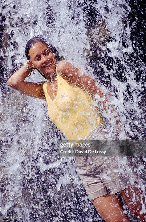 Woman Standing Under Waterfall Smiling Photo Getty Images