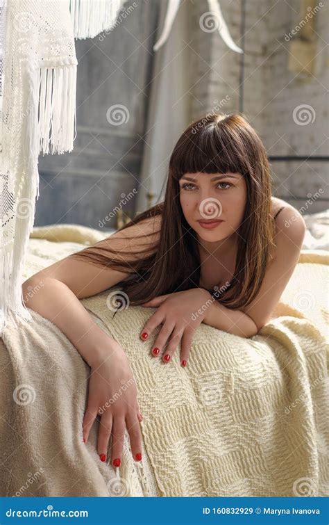 Portrait Of Middle Aged Woman In Lingerie Posing On The Bed In The