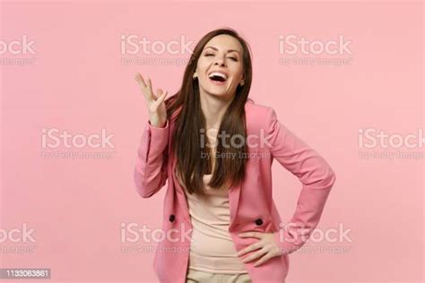 쾌활 한 웃는 예쁜 젊은 여자의 초상화에 재킷 서 스튜디오에서 파스텔 분홍색 벽 배경에 고립 된 손을 확산 사람들은 진심으로 감정 라이프 스타일 개념입니다 복사 공간을 모의