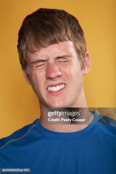 Closeup Of Young Man With Eyes Closed And Clenched Teeth High Res Stock