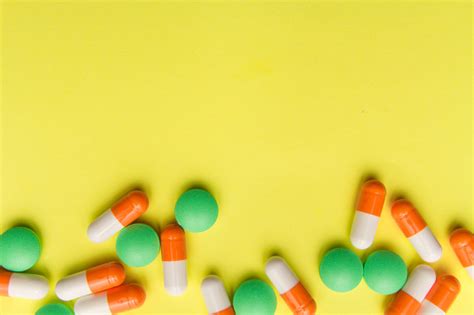 藥用綠色藥丸和橙色膠囊在黃色背景與拷貝空間治療藥物的處方醫學背景範本 照片檔及更多 乙醯水楊酸 照片 乙醯水楊酸 人 健保和醫療