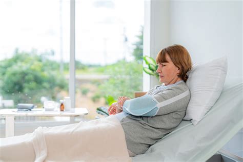 병원에서 부러진 팔 지지대를 착용하고 침대에 누워있는 노인 환자 여성 외롭고 다친 팔이 부러진 느낌 의료 및 보험 개념 치료 후 팔에 부상당한 여성의 통증 부러진 팔에 대한