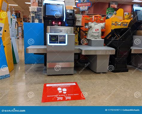 Signs Instructing Social Distancing At The Self Checkout Lines At A