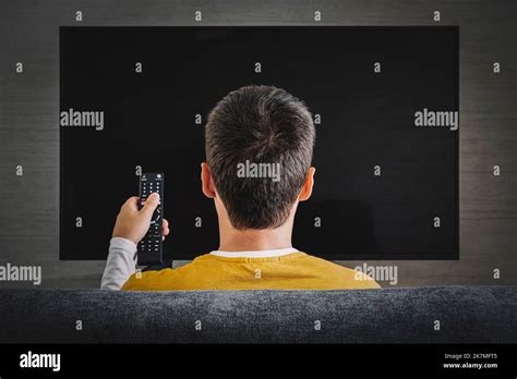 Man Watching Television Turning On Plasma Flatscreen TV Set Pointing