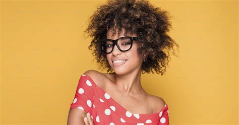 웃고 있는 아름다운 아프리카계 미국인 젊은 여성의 초상화 안경을 쓴 아프리카를 가진 소녀 노란색 배경입니다 스튜디오 촬영 사진 Unsplash의 아프리카 계