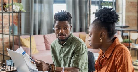 젊은 아프리카계 미국인 부부는 집에서 테이블에 앉아 세금 신고서를 작성하는 동안 서류를 분석합니다 사진 Unsplash의 러시아 이미지