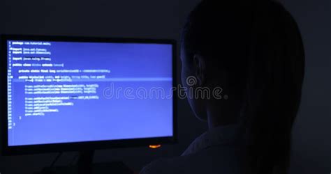 Portrait Of Young Woman Hacker Programmer Working At A Computer In The