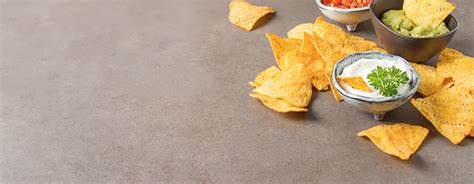 스낵 파티 옥수수 칩 나 초 소스 토마토 사 우 어 크림과 아보카도 소스와 살사 멕시코 음식입니다 어두운 배경입니다 공간 복사