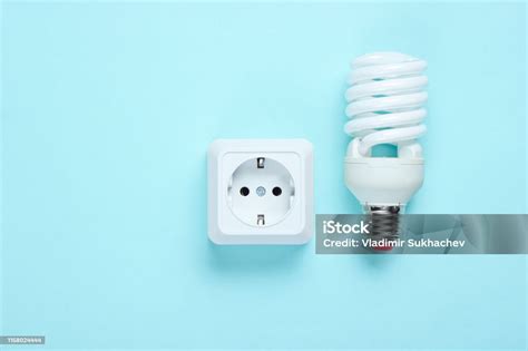 藍色背景上的白色塑膠電源插座和螺旋燈泡極 簡 主義頂部視圖 照片檔及更多 創作性 照片 創作性 創新 器材 Istock