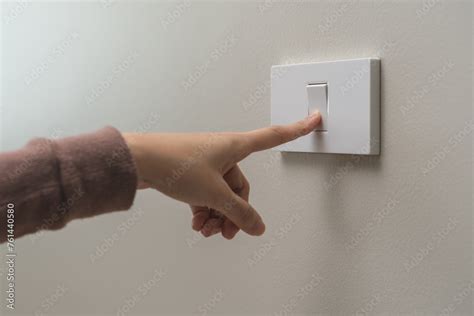 Close Up Of Hand Of Woman Turn Off On Lighting Switch At Home Room Finger Pushing Light Switch