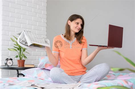 女孩手里拿着报纸和笔记本电脑看高清图片下载 正版图片307055821 摄图网