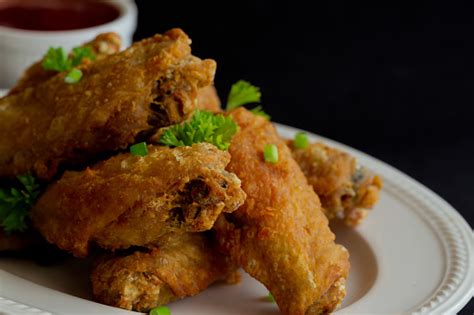 바베 큐 소스를 찍기와 함께 흰색 접시에 튀긴 닭 날개 싱 싱 하 고 맛 있는 수 제 튀김된 닭입니다 튀긴된 닭고기와 칠리 소스 또는 토마토 소스 봉사 준비를 닫습니다 닭