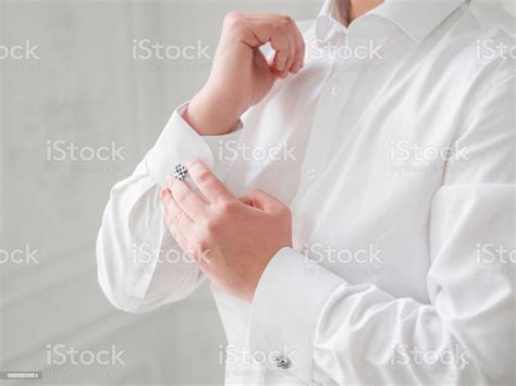 흰 셔츠에 남자는 그의 커 프 스 단추를 조정합니다 신랑은 결혼식을 위한 준비입니다 개인 장식품에 대한 스톡 사진 및 기타