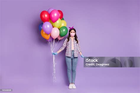 밝은 보라색 배경에 고립 된 풍선으로 생일을 축하하는 얼굴 마스크 장갑을 착용 한 갈색 머리 소녀의 전체 길이 신체 크기 사진 갈색 머리에 대한 스톡 사진 및 기타 이미지