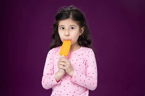 보라색 배경 위에 고립 된 서 아이스크림을 먹는 인도 귀여운 아이 소녀의 초상화 스톡 사진 4 5세에 대한 스톡 사진 및 기타