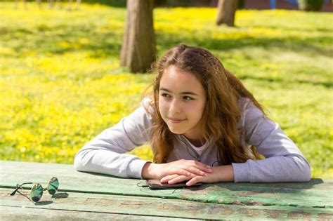 Premium Photo Portrait Of A Girl Smiling While Sitting On Table