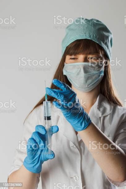 라텍스 장갑에 의료 용 마스크와 손을 가진 여성은 예방 접종 개념을 보여줍니다 간호사가 주사기를 들고 있습니다 코로나바이러스에