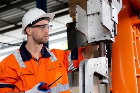 젊은 백인 엔지니어 남자 검사 로봇은 공장에서 무선 명령 기술자 확인 및 유지 보수 기계 로봇 산업 개념을 말하면서 기술 지능과