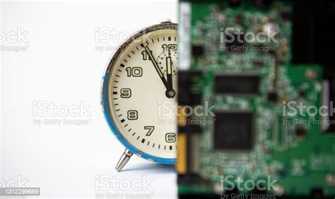 흰색 배경에 오래 된 아날로그 파란색 시계 시계는 5 분에서 12시까지의 시간을 보여주며 앞에는 일부 전자 장치로 만든 인쇄 회로 기판이 있습니다 차에 대한 스톡 사진 및