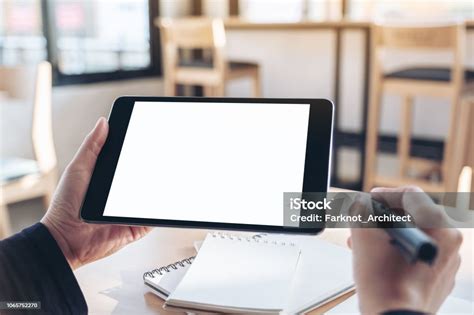 누른 채 사무실에서 노트북에 쓰는 동안 빈 흰색 바탕 화면으로 검은 Tablet Pc를 사용 하 여 손의 이랑 이미지 개념에