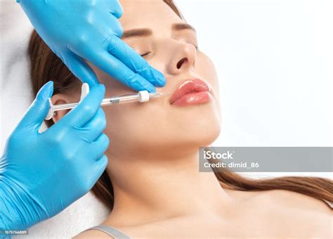 아름다운 갈색 머리 여자 에 The 미용사 미용사는 얼굴과 광대뼈에 주름 주사를 방지합니다 뷰티 살롱의 여성 화장품 보톨리눔