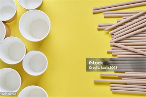 종이와 옥수수 전분으로 만든 튜브 생분해성 재료 및 녹색 새싹 잎이있는 에코 종이 안경은 노란색 트렌드 색상 2021 배경에