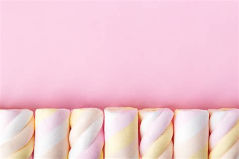 파스텔 핑크 배경에 달콤한 여러 가지 빛깔의 마시멜로의 행 클로즈업 맛있는 부드러운 과자 복사 공간이있는 평평한 누워 비틀어진에