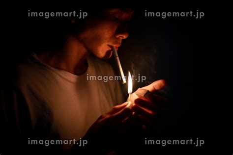 マッチでタバコに火をつける男性の写真素材 159473121 イメージマート