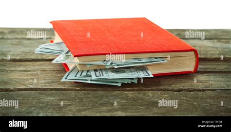 red book with nested dollar banknotes on white background stash of