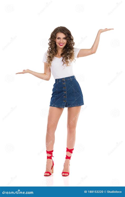 Young Woman In Mini Skirt And High Heels Holds Hands Raised And