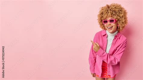Overjoyed Stylish Woman Wears Sunglasses Shirt And Skirt Points Finger