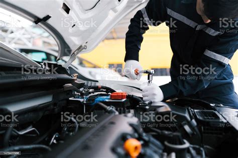 차고에서 자동차 엔진 작업을위한 렌치를 사용하는 전문 자동차 정비사는 떠나기 전에 자동차 자동차 수리 서비스 및 유지 보수 점검 개념을 제공합니다 50 54세에 대한 스톡