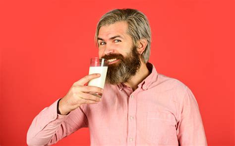행복한 농부는 우유 유리를 선물합니다 수염이있는 사람은 유용한 우유를 마 십니다 건강한 음식과 음료 유리에 비 유제품 코코넛