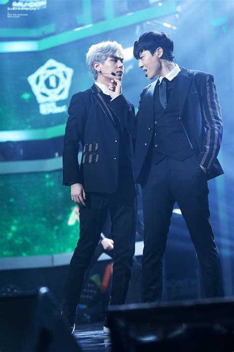 Two Men Standing Next To Each Other On Stage