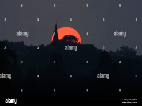 Sunsetting Behind A Church Steeple Stock Photo Alamy