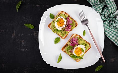 으깬 아보카도 삶은 달걀 향신료 및 적양파를 곁들인 건강한 토스트 맛있는 아침 식사 또는 간식 평면도 0명에 대한 스톡 사진 및