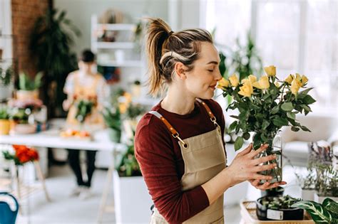 활기찬 꽃집에서 노란 장미를 꽂아놓고 꽃 디자인에 대한 그녀의 기술과 열정을 보여주는 쾌활한 플로리스트 2명에 대한 스톡 사진 및 기타 이미지 Istock