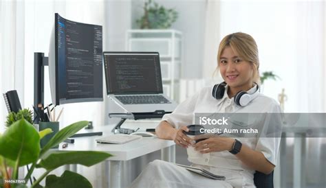 Female Programmers Sitting Front Of Laptop And Large Curved Computer