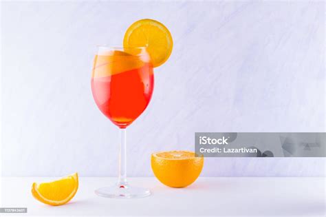 칵테일 아돌이 흰색 바탕에 뿌려 진다 오렌지 조각과 함께 여름 알코올 칵테일 화이트 보드에 이탈리안 칵테일 아콜이 뿌려 졌습니다